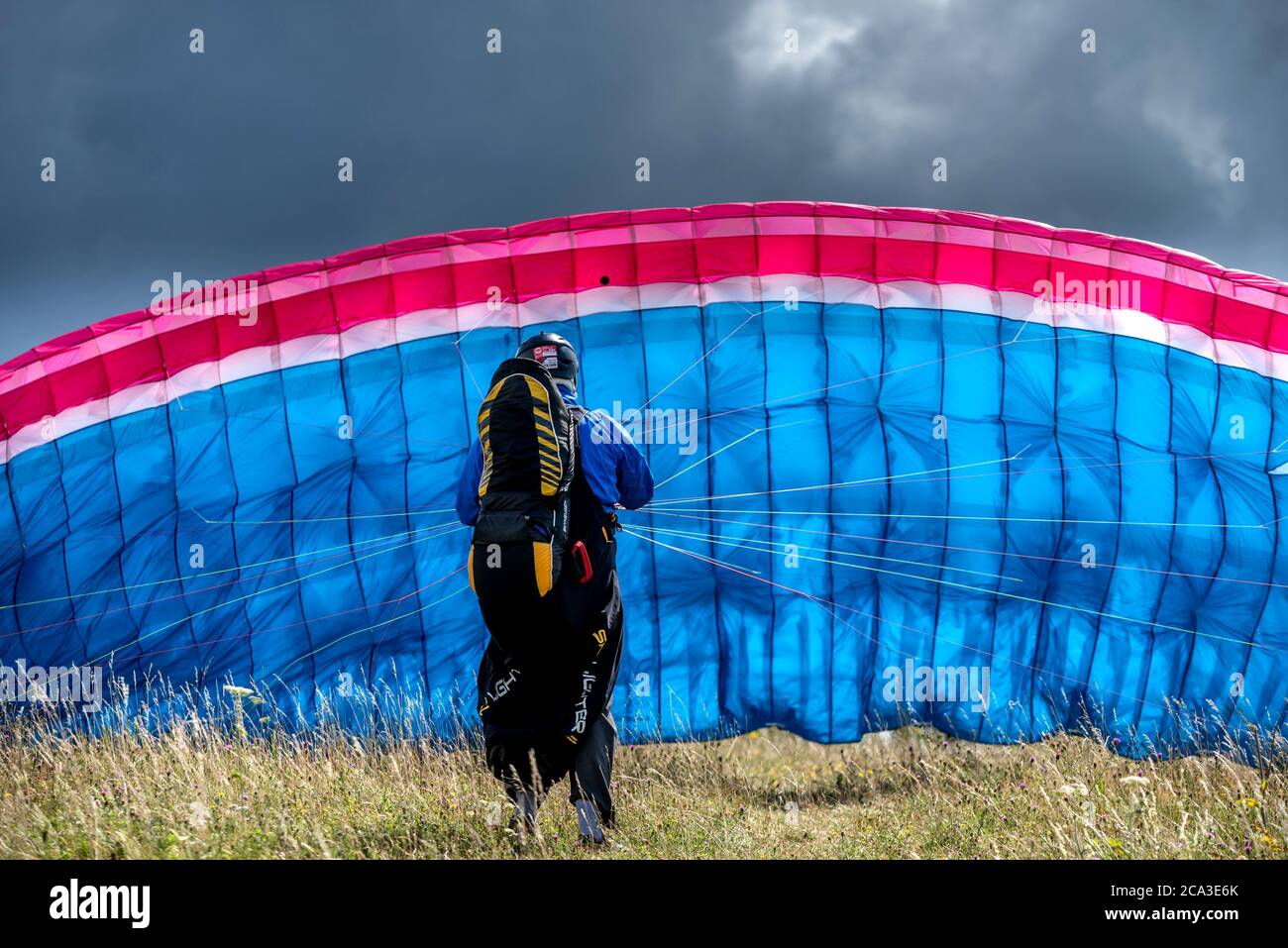 Brighton UK, August 3rd 2020: A paraglider getting ready for take-off in the South Downs ...