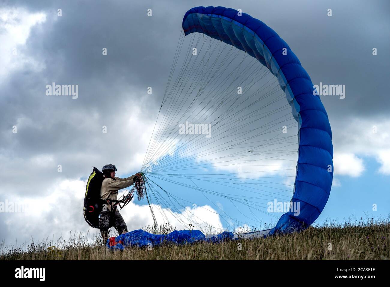 Brighton UK, August 3rd 2020: A paraglider getting ready for take-off in the South Downs ...