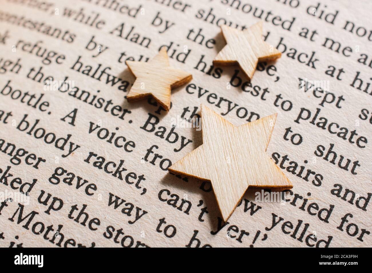 Little wooden stars placed on book page Stock Photo - Alamy