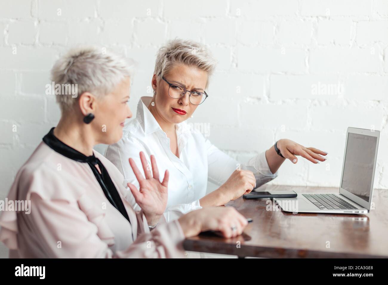 Businesswoman looking at computer presentation on laptop screen at ...