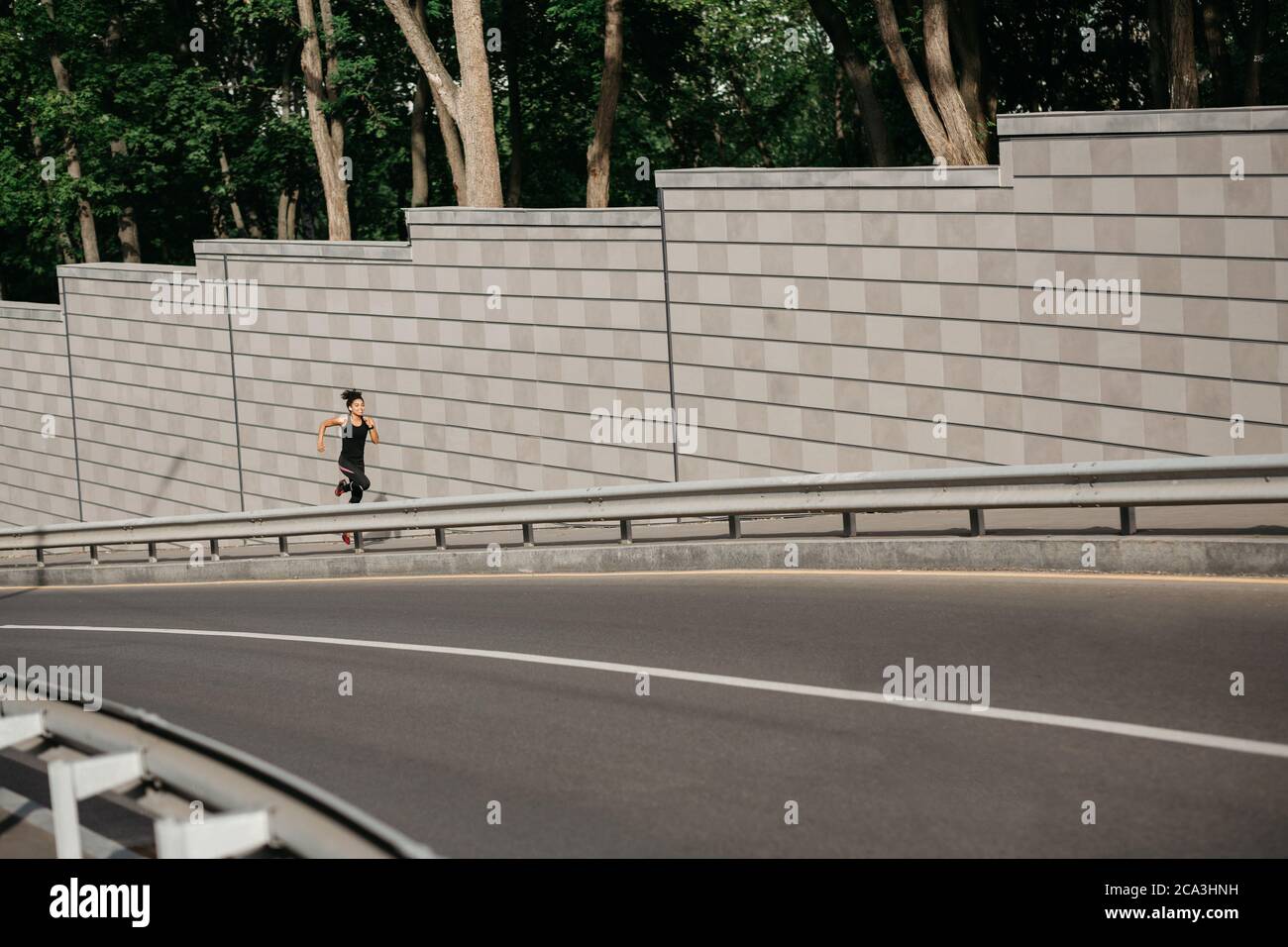 Female runner sprinting on street. African american girl in sportswear ...