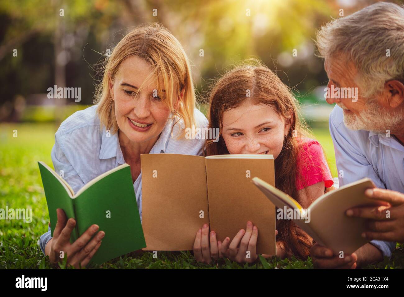 Happy family read books together in park garden Stock Photo - Alamy