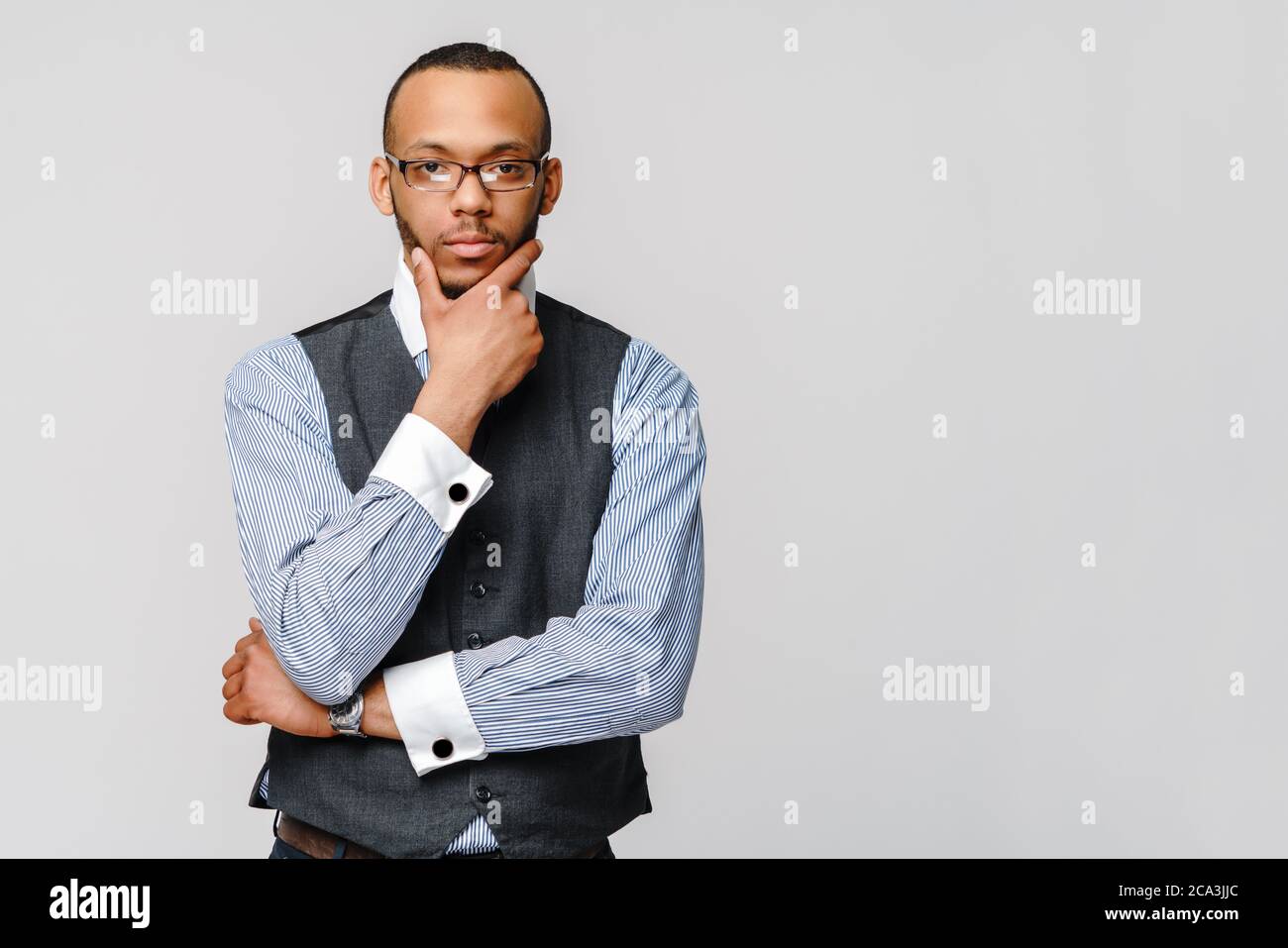 Studio shot of young African-American businessmanman over grey ...