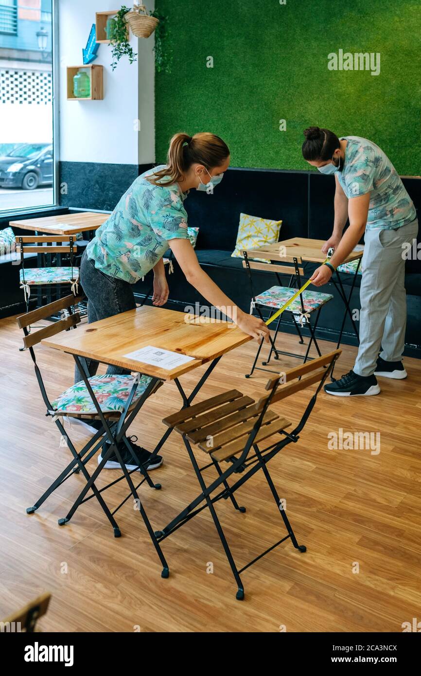 Workers measuring social distance between tables Stock Photo - Alamy