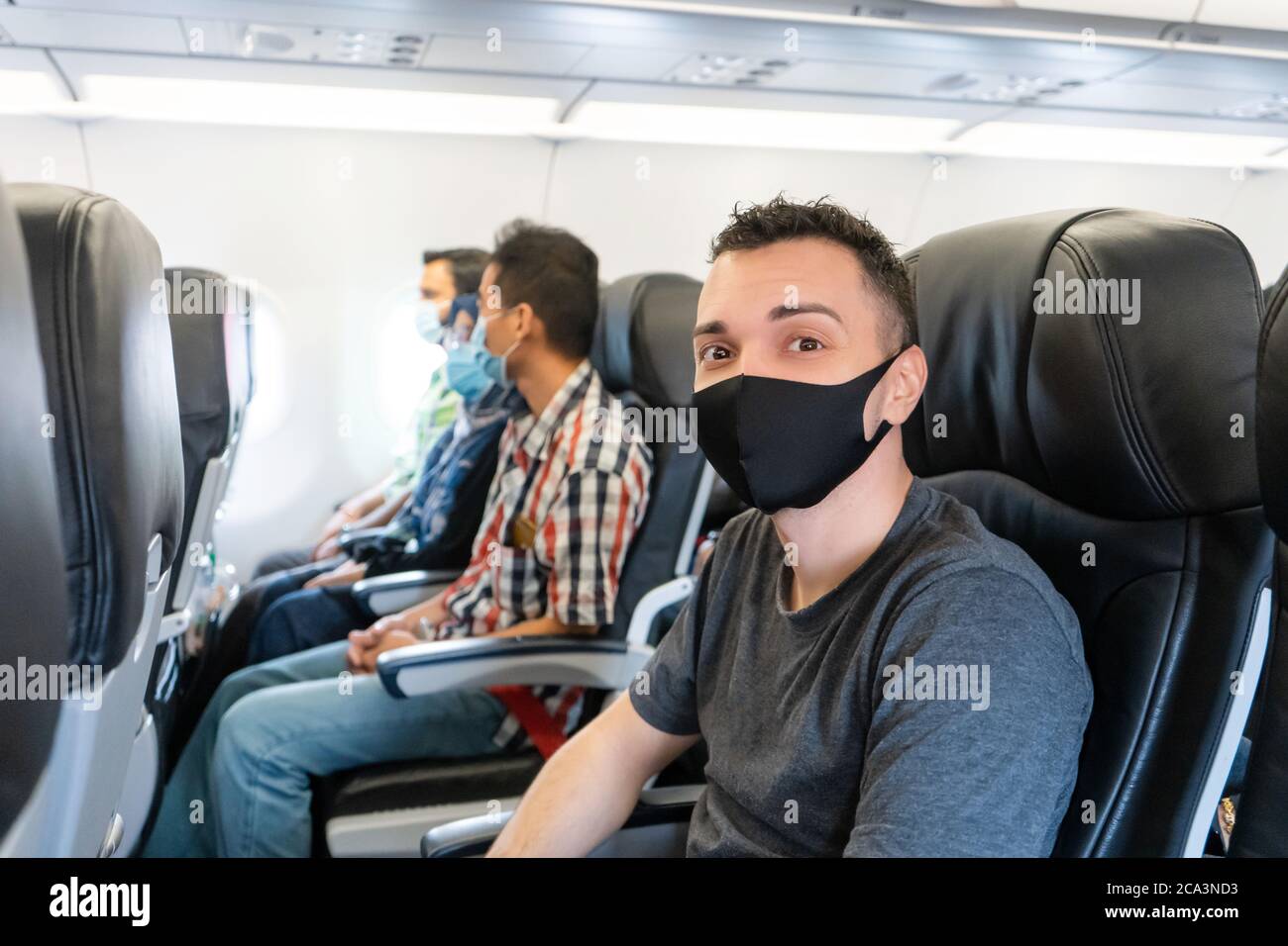 Airplane passengers are wearing medical masks on their faces. Air ...
