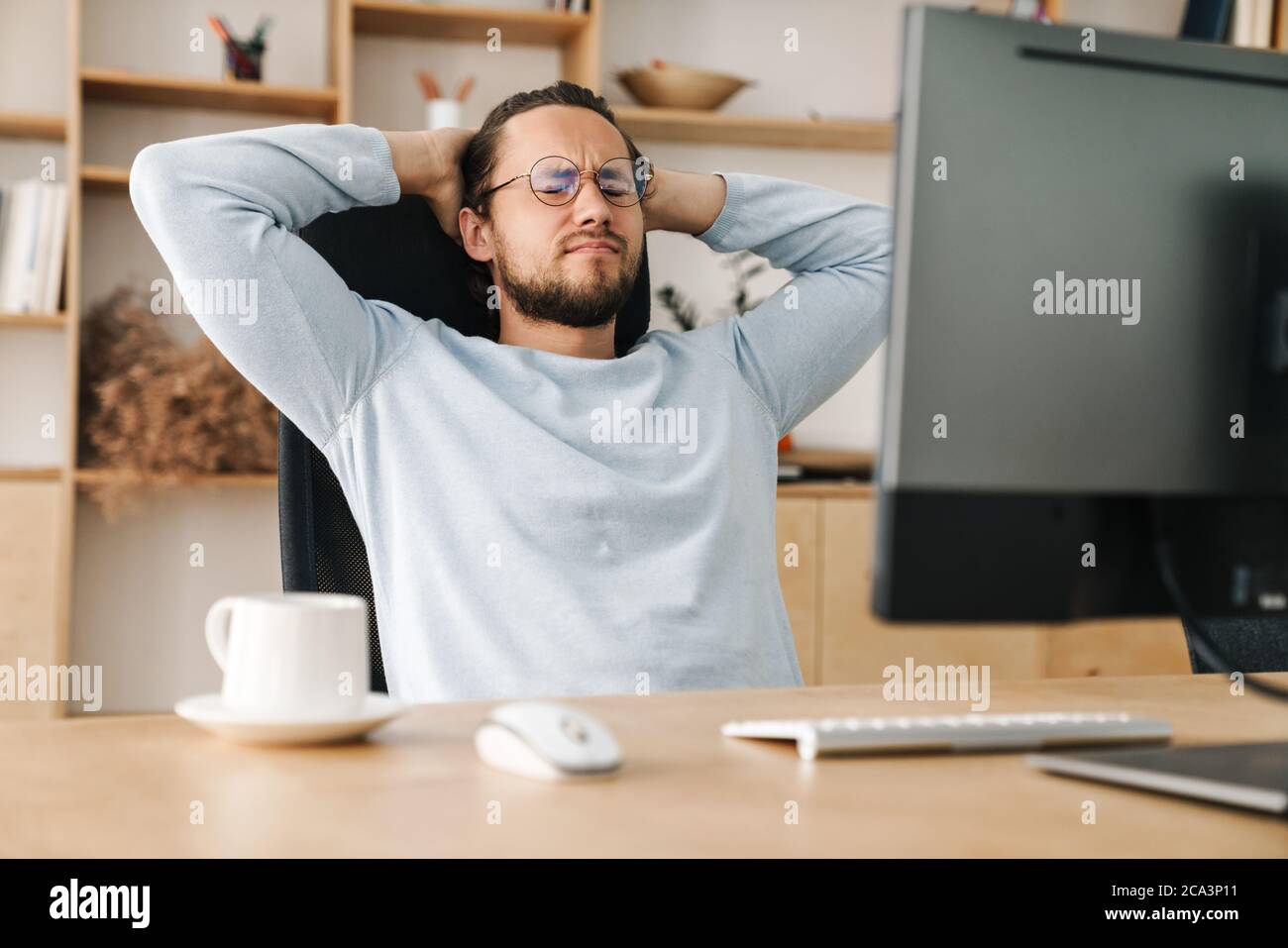 Image of unhappy bearded programmer man wearing eyeglasses working with computer in office Stock ...