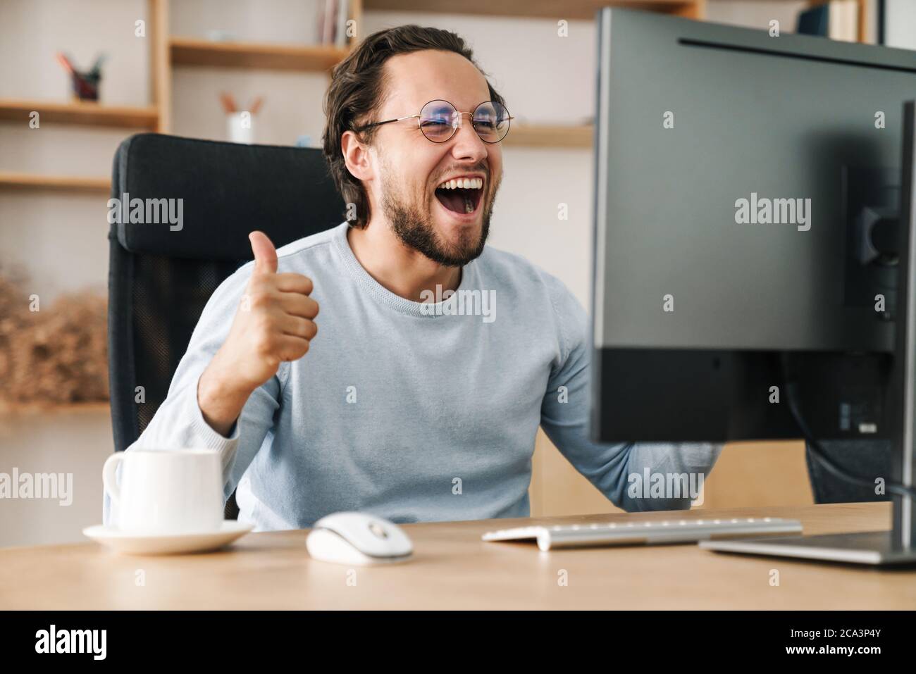 Image of excited programmer man showing thumb up while working with computer in office Stock ...