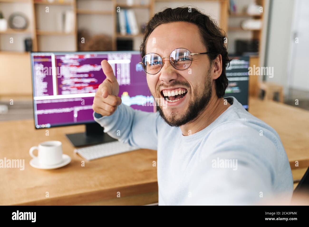 Image of unshaven excited programmer man pointing finger at camera ...