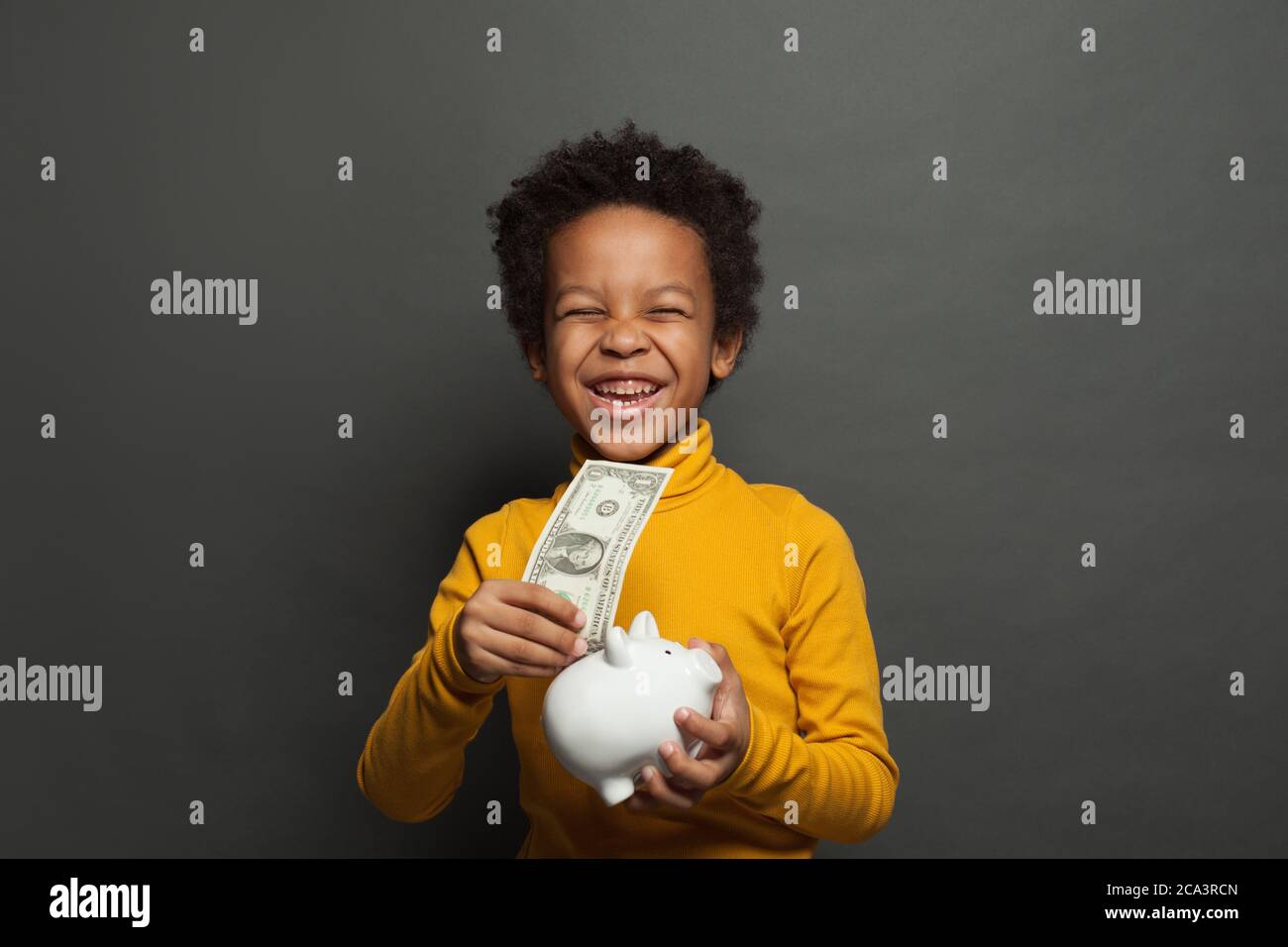Laughing black child with money box and one us dollar on blackboard ...