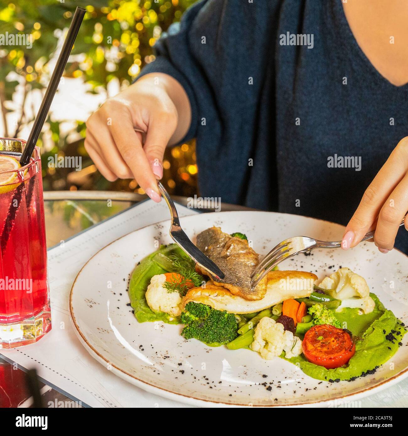 Woman eating fish hi-res stock photography and images - Alamy