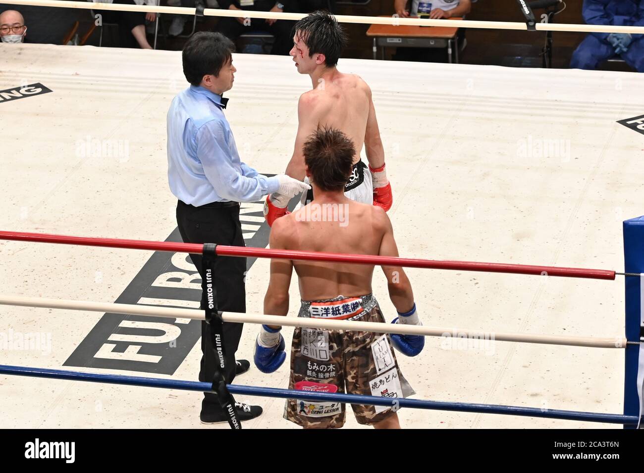 Referee Katsuhiko Nakamura stops the fight champiopn Kenta Nakagawa ...