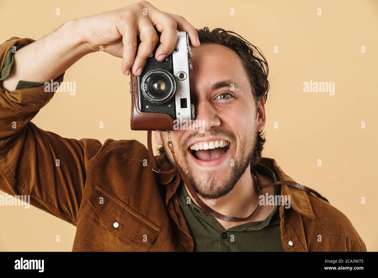 Image of laughing caucasian man taking photo on retro camera isolated ...