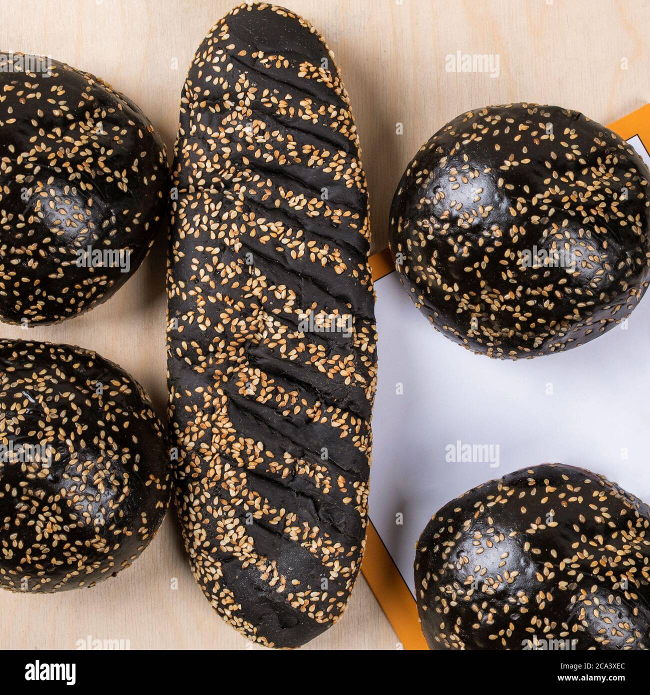 Fresh dark, black burger and baton bread top view Stock Photo - Alamy