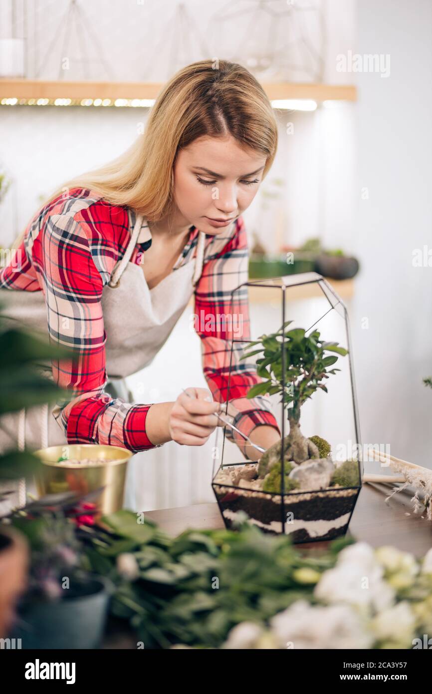 careful florist lady with long blonde hair in red casual checkered ...