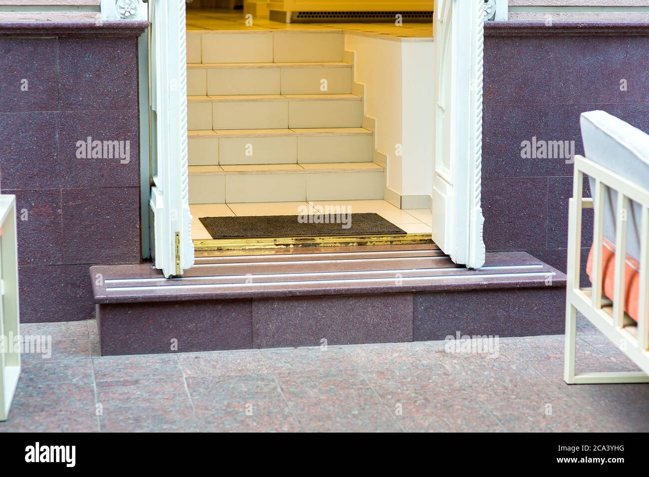 entrance to the cafe from the street on the stone steps through a white ...