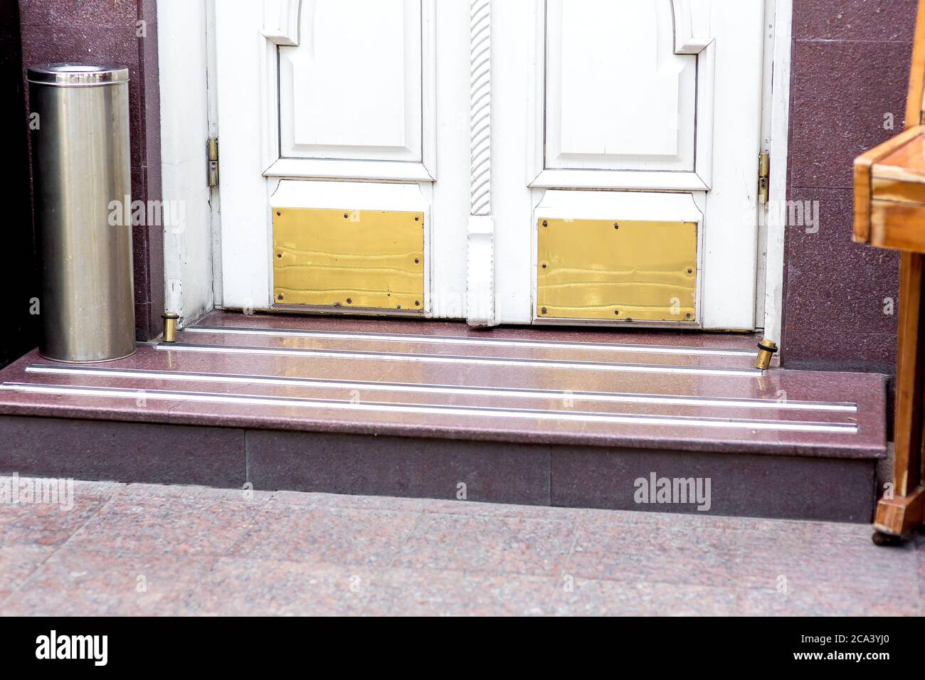 the entrance to the wooden door with a threshold of stone tiles and a ...