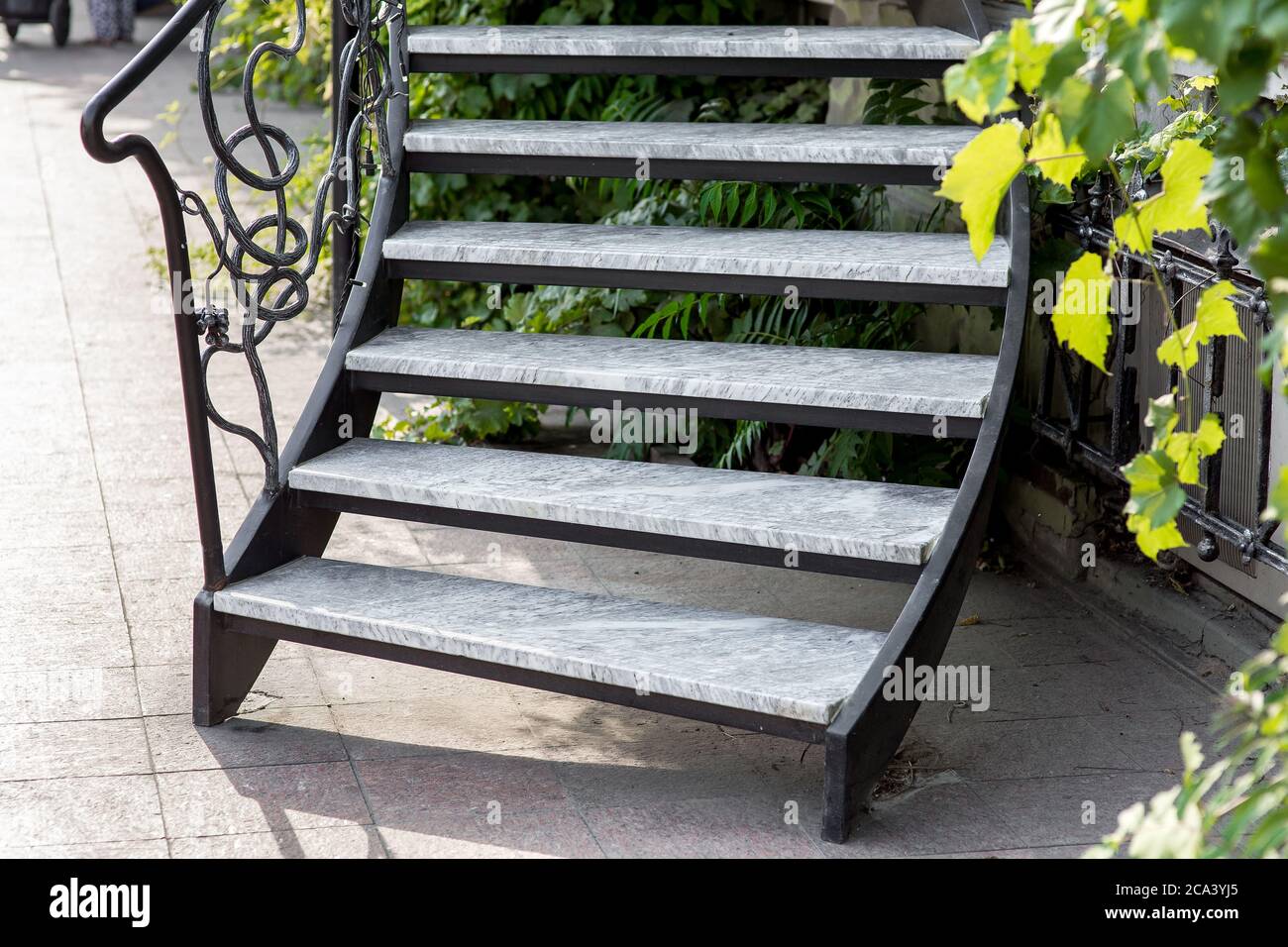 iron forged stairs with marble steps, close-up of the entrance ...
