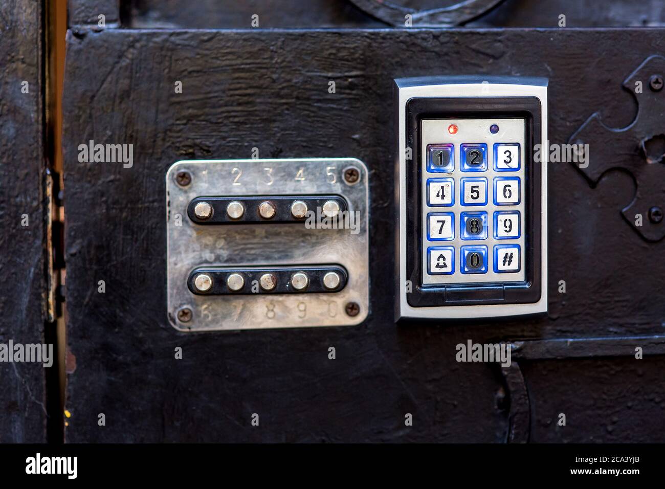 a black iron gate with a combination lock, an old mechanical lock with ...
