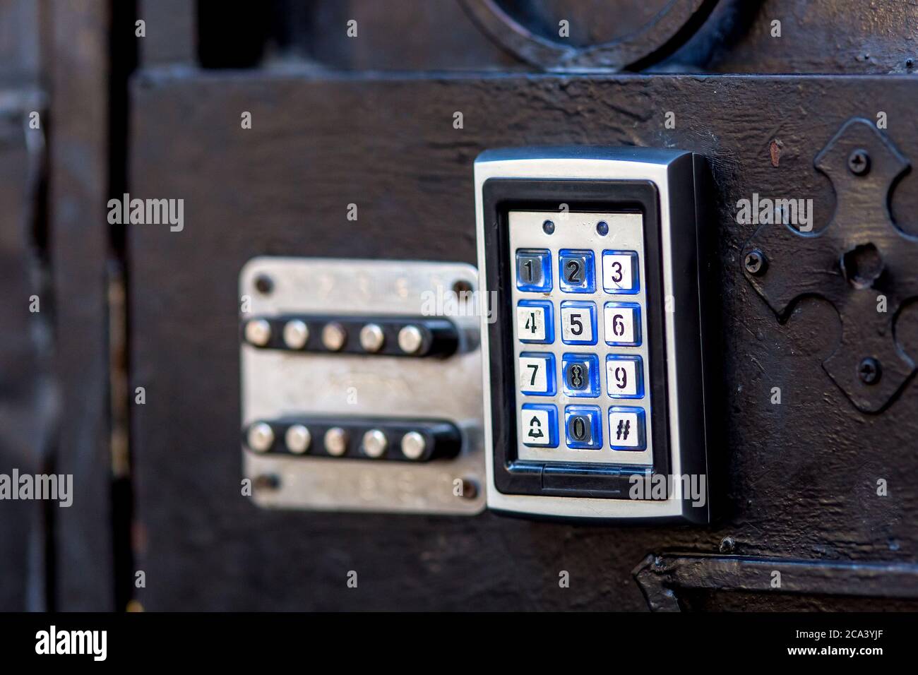 combination lock on a black iron gate with electronic buttons and old ...