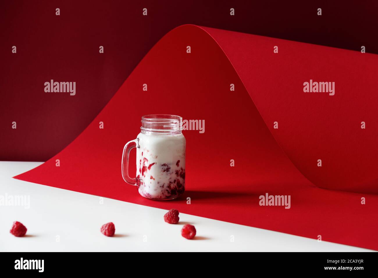 Fresh raspberry milkshake on creative red and white background. Summer ...
