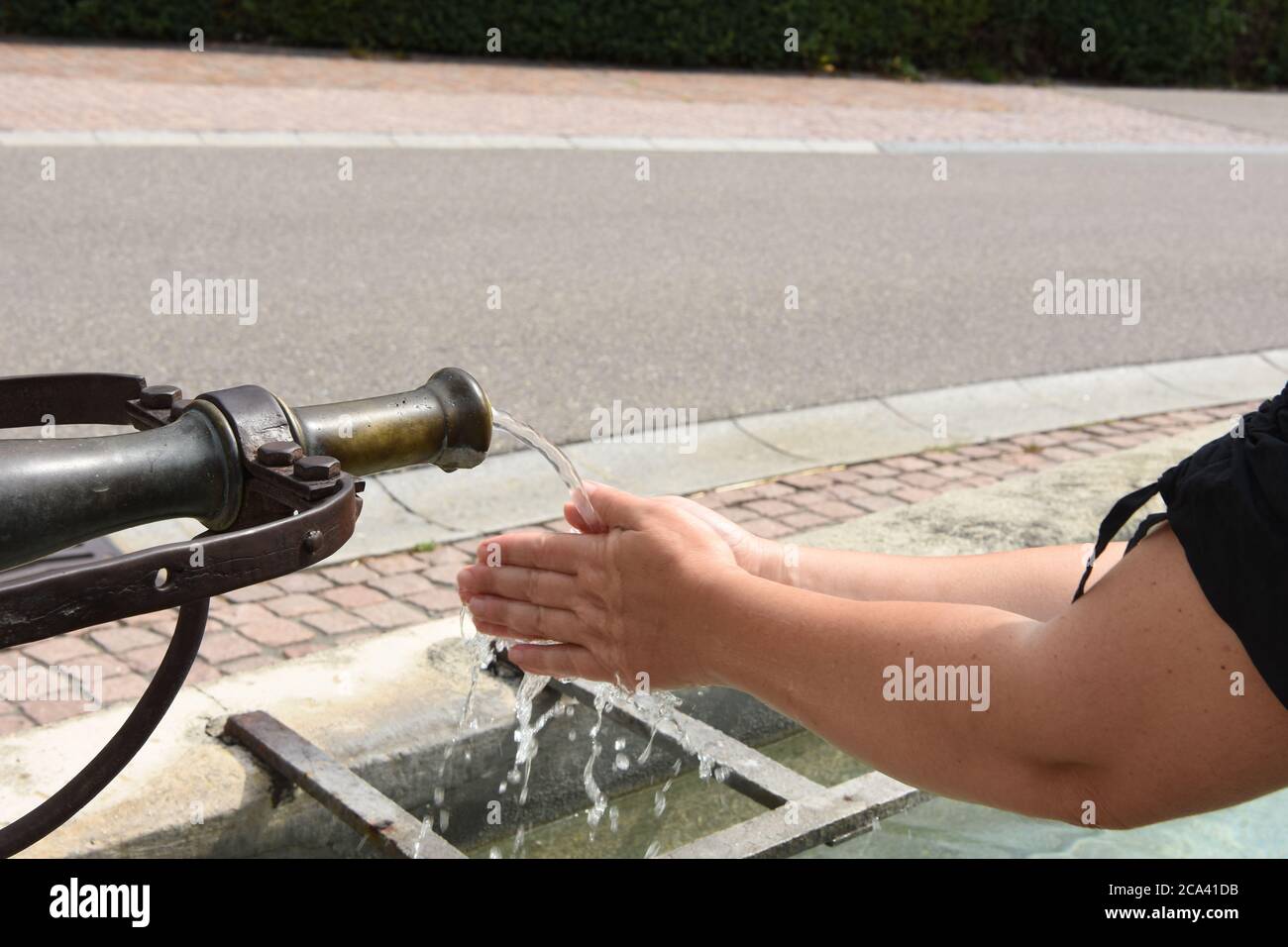 Washing hands and refreshing in hot summer weather in a public drinking ...