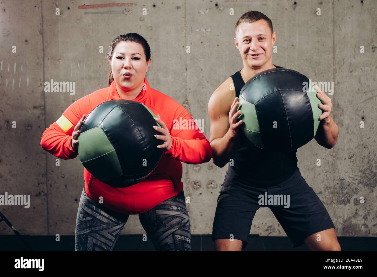 emotional positive couple doing exercises with balls in the fitness ...