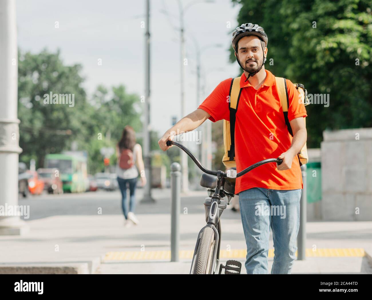 Traffic light and pedestrian crossing in city. Friendly courier in ...