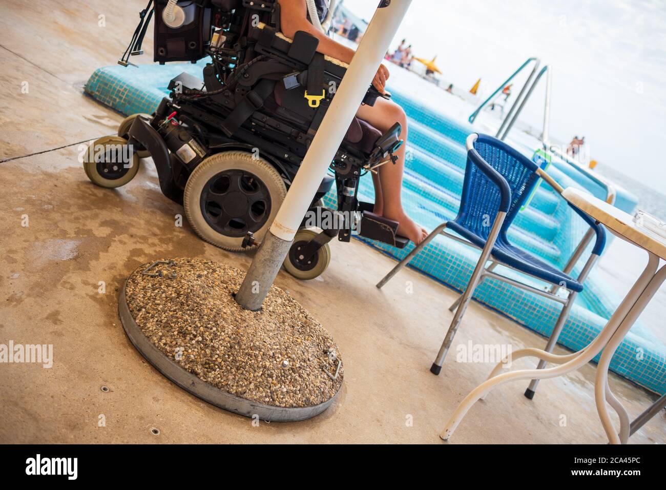 Accessible beach and pool with a wheelchair person Stock Photo - Alamy