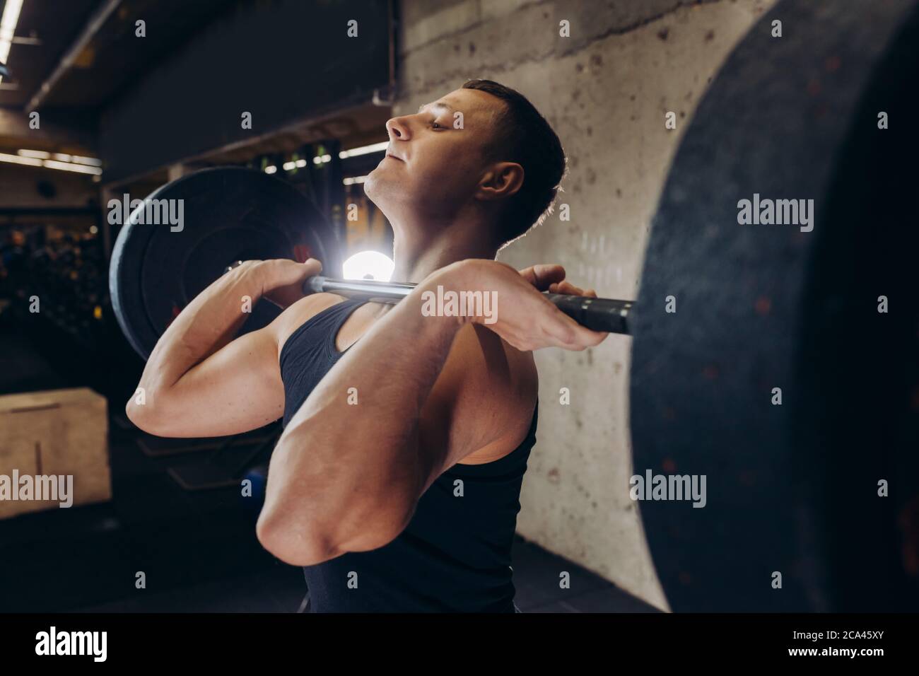 muscular fit guy training with barbell. close up side view photo. hobby ...