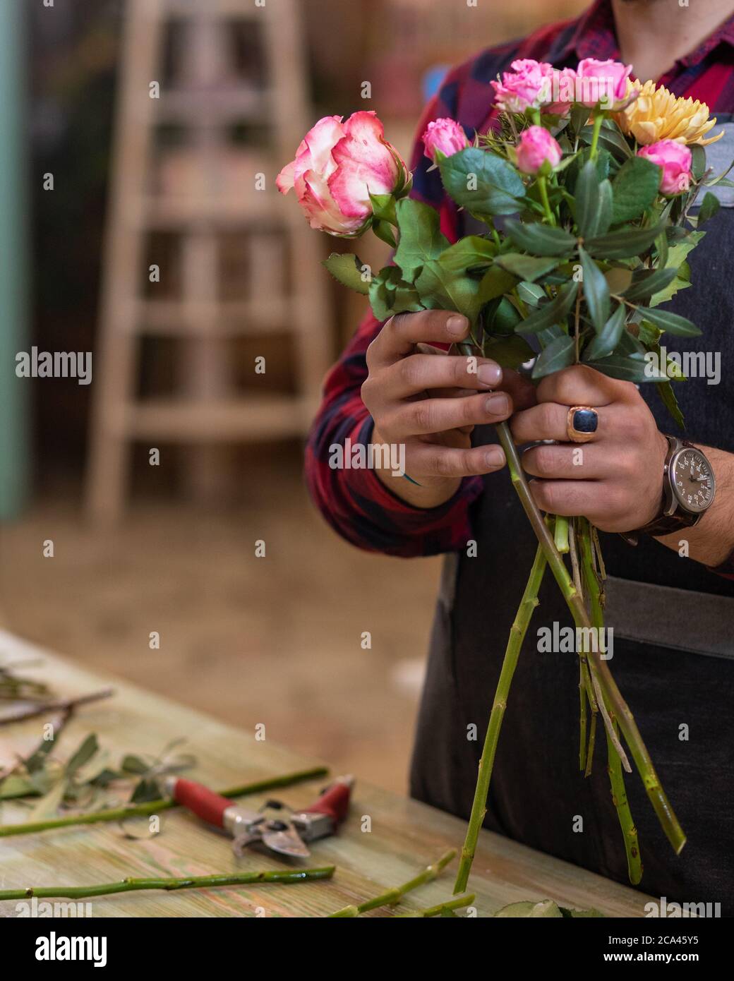 Florist man making flower bouquet at the store Stock Photo - Alamy