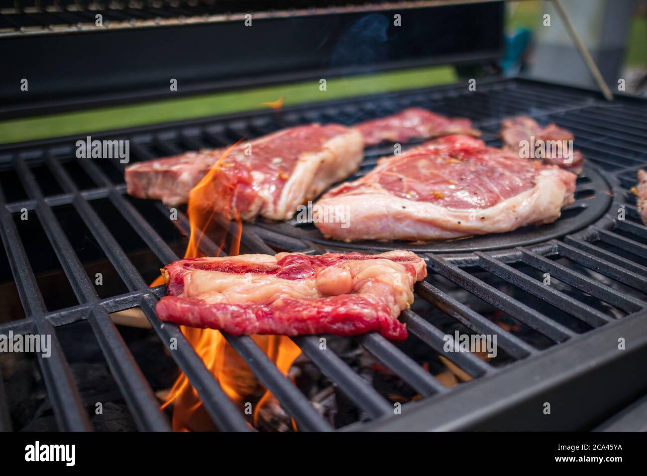 Home barbecue with charcoal in the backyard grilling steaks and other ...