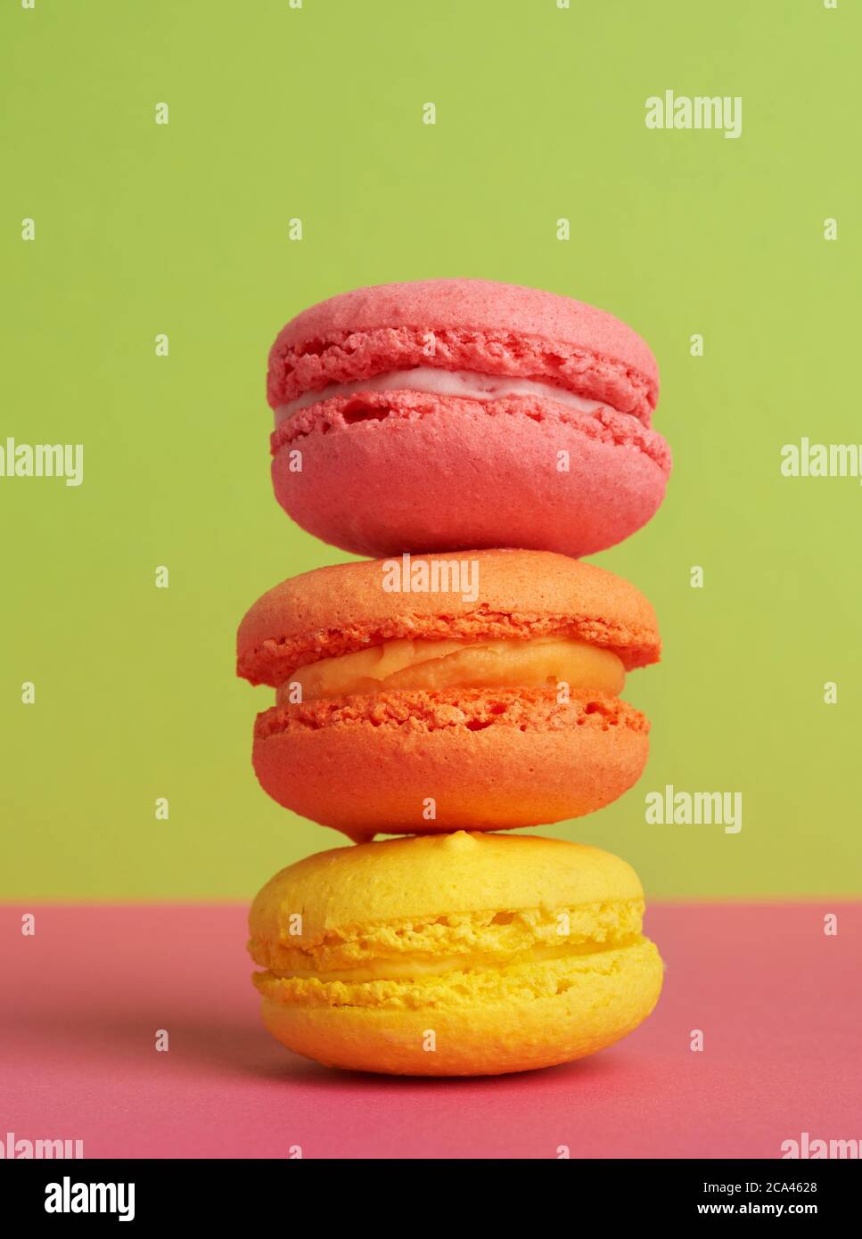 three round multi-colored baked macarons, the dessert lies on top of ...