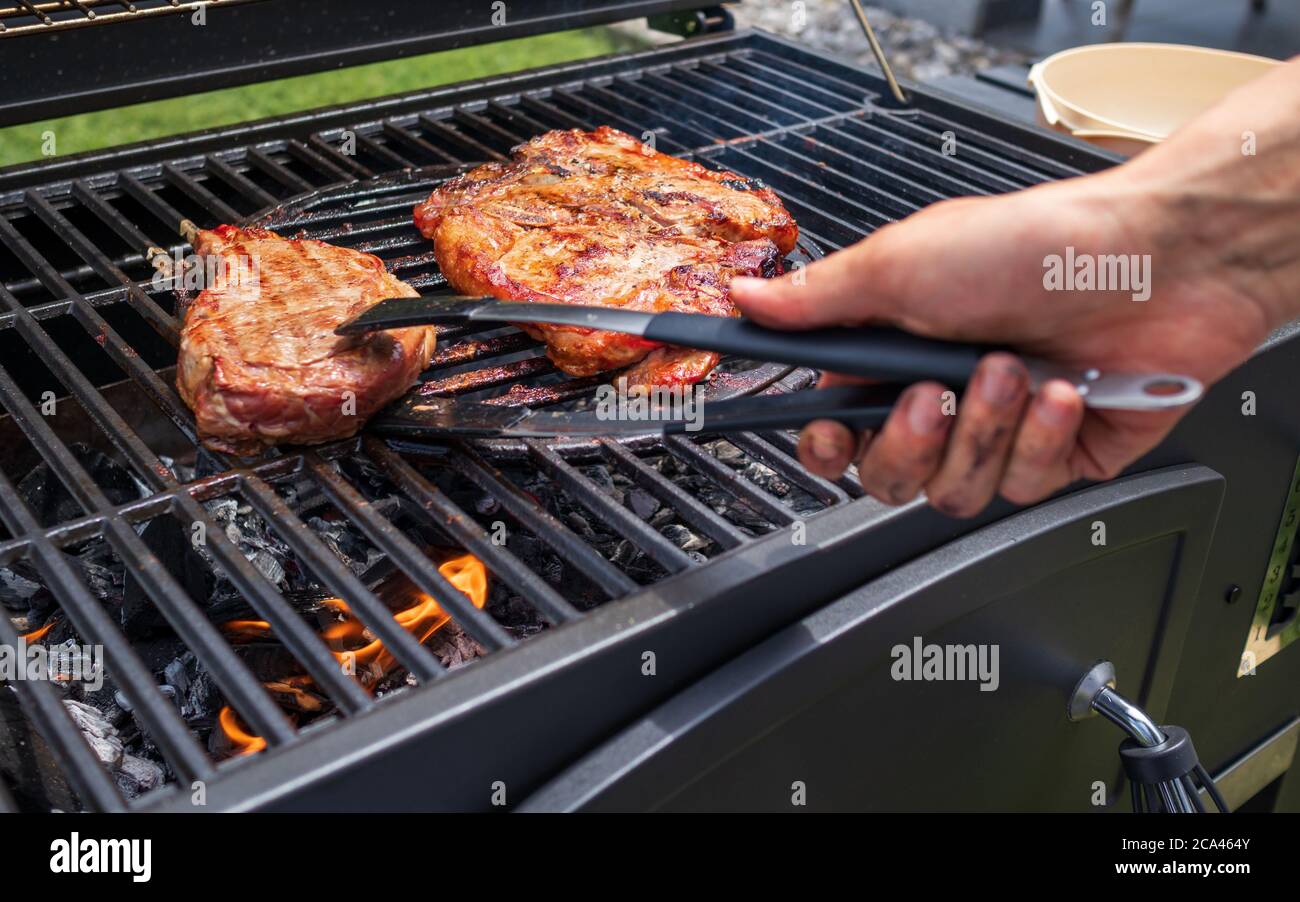 Home barbecue with charcoal in the backyard grilling steaks and other ...