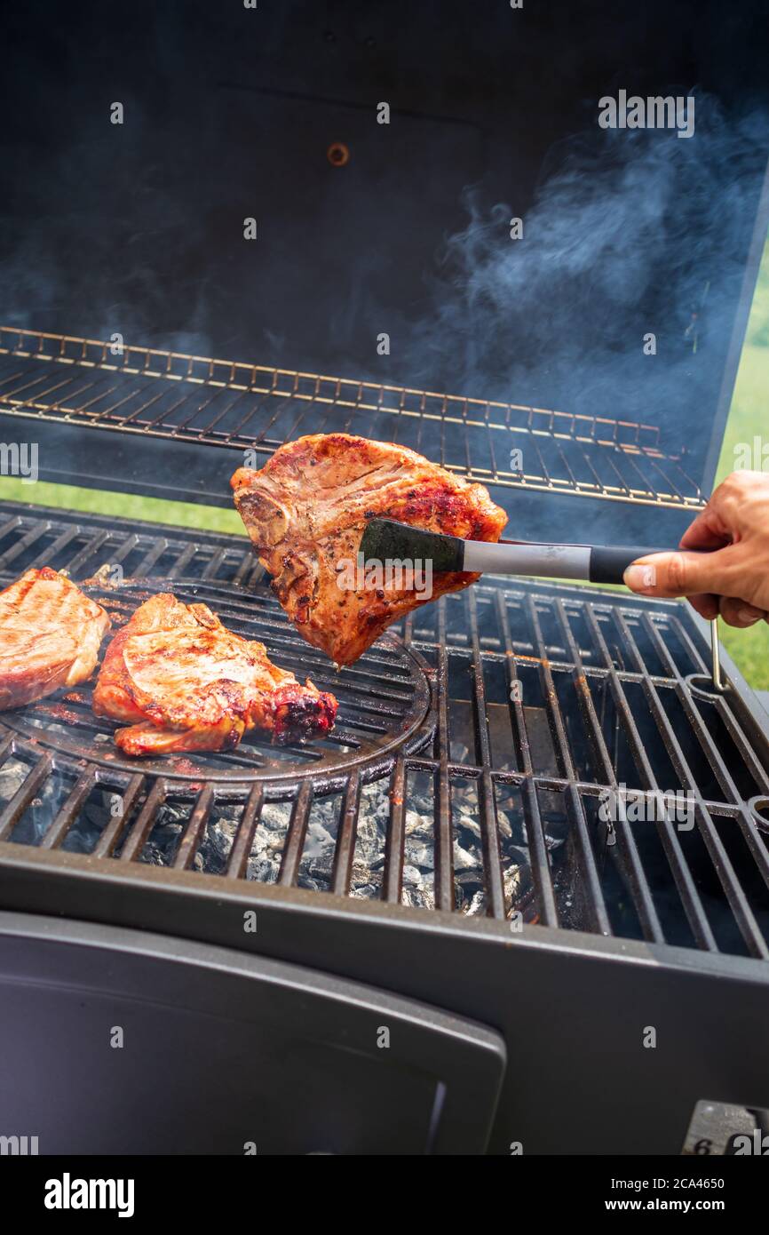 Home barbecue with charcoal in the backyard grilling steaks and other ...