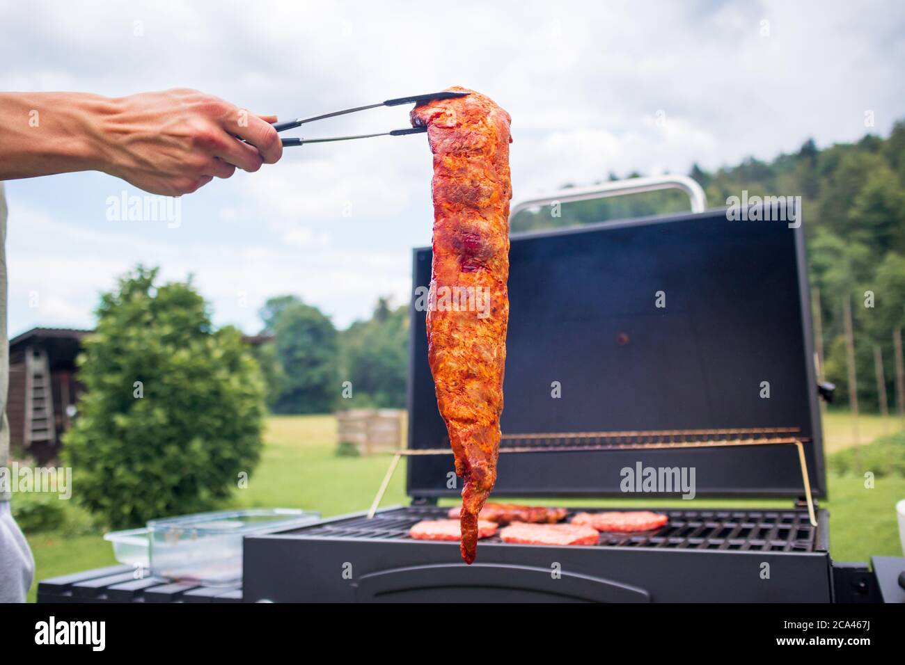 Home barbecue with charcoal in the backyard grilling steaks and other ...