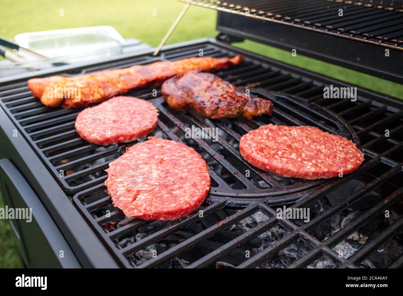Home barbecue with charcoal in the backyard grilling steaks and other ...