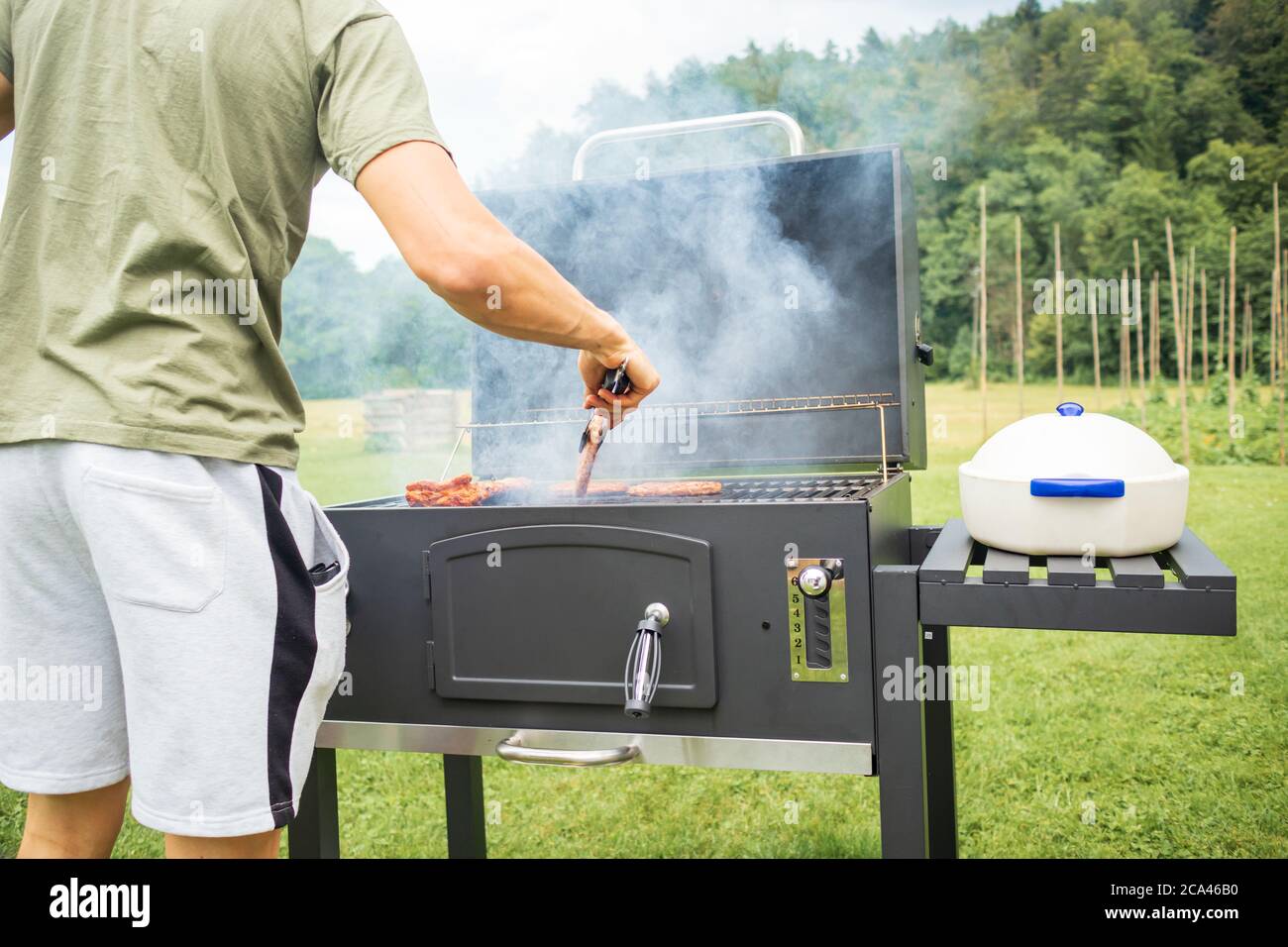 Home barbecue with charcoal in the backyard grilling steaks and other ...