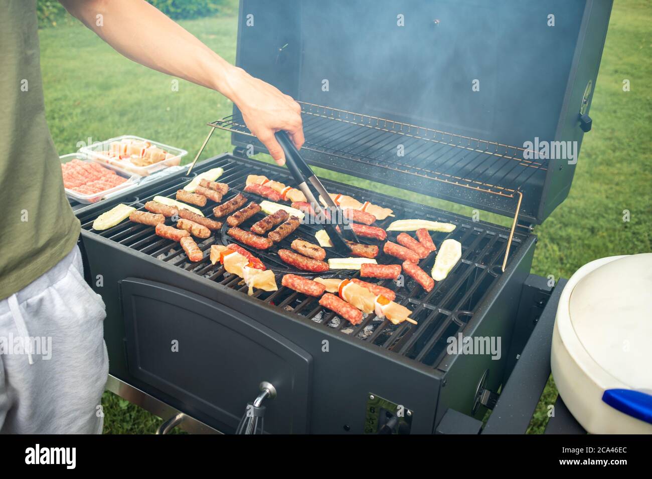 Home barbecue with charcoal in the backyard grilling steaks and other ...