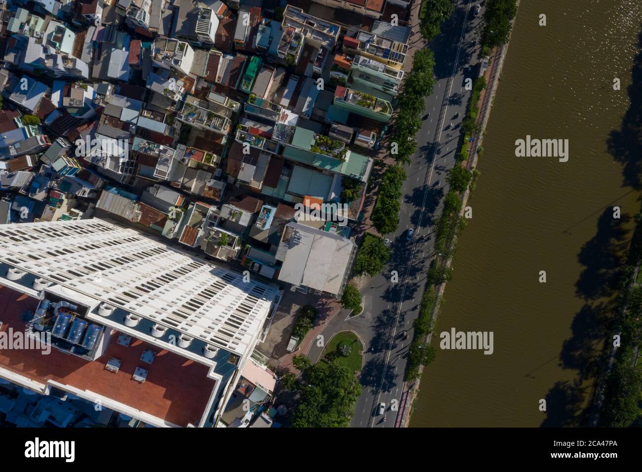 Dramatic top down view of modern apartment building with road, river ...