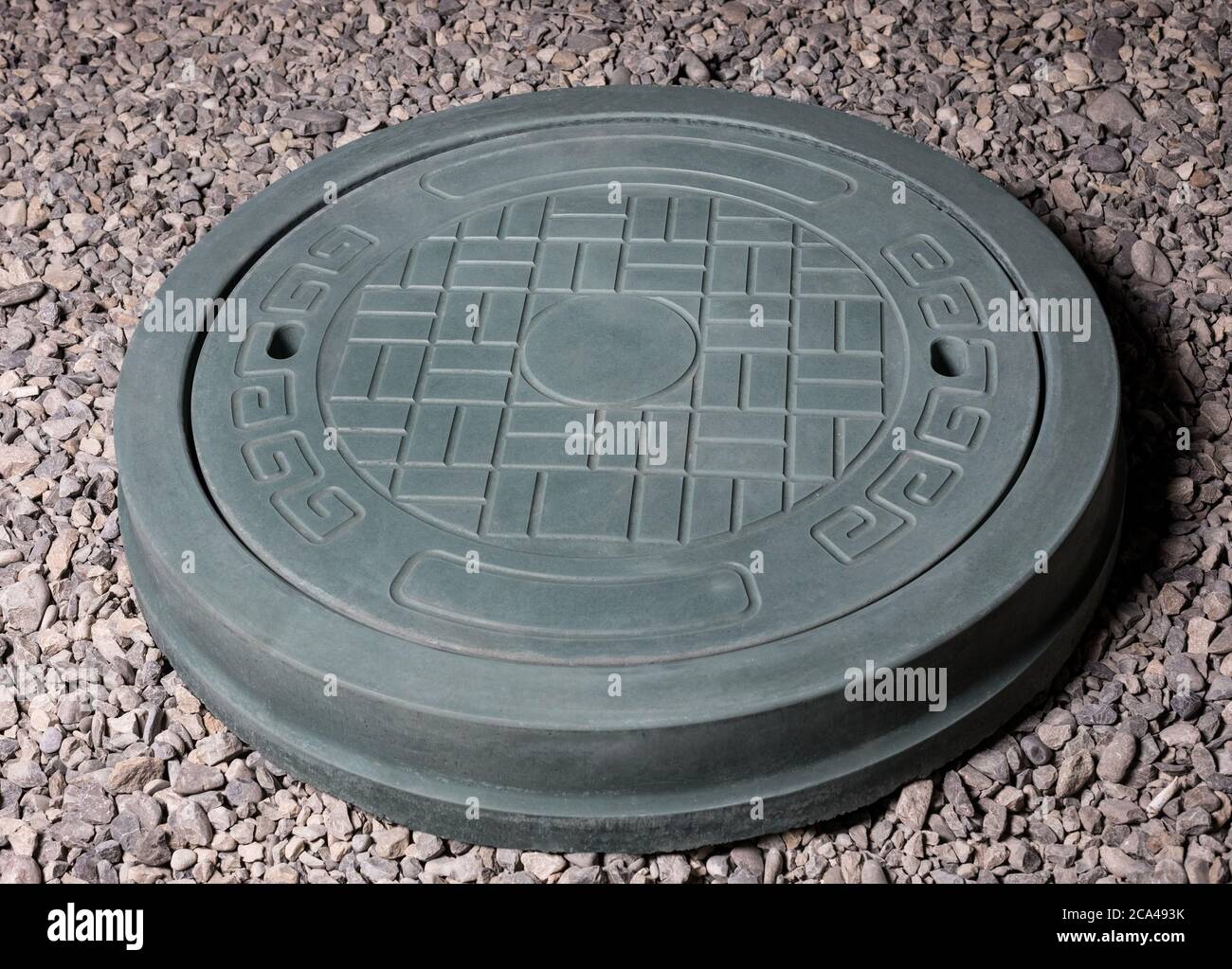 Plaster graceful stone manhole shape on the ground Stock Photo - Alamy