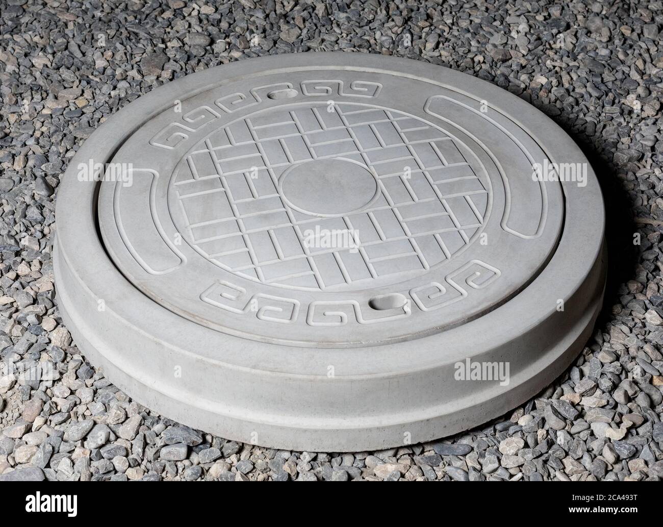 Plaster graceful stone manhole shape on the ground Stock Photo - Alamy