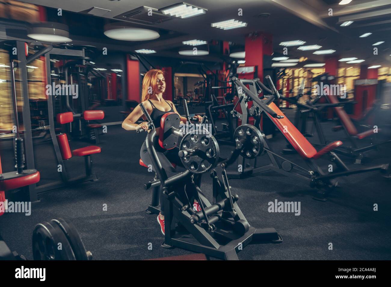 Heavy. Young muscular caucasian woman practicing in gym with equipment ...