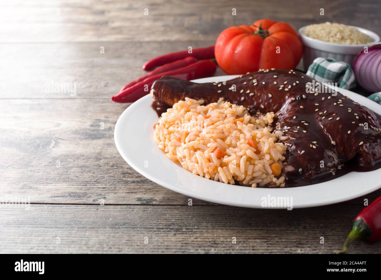 Traditional mole Poblano with rice in plate on wooden table Stock Photo ...