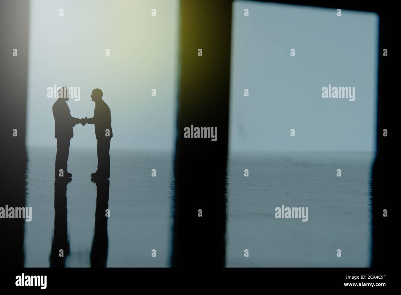 Silhouette of two businessmen make an handshake partnership agreement ...