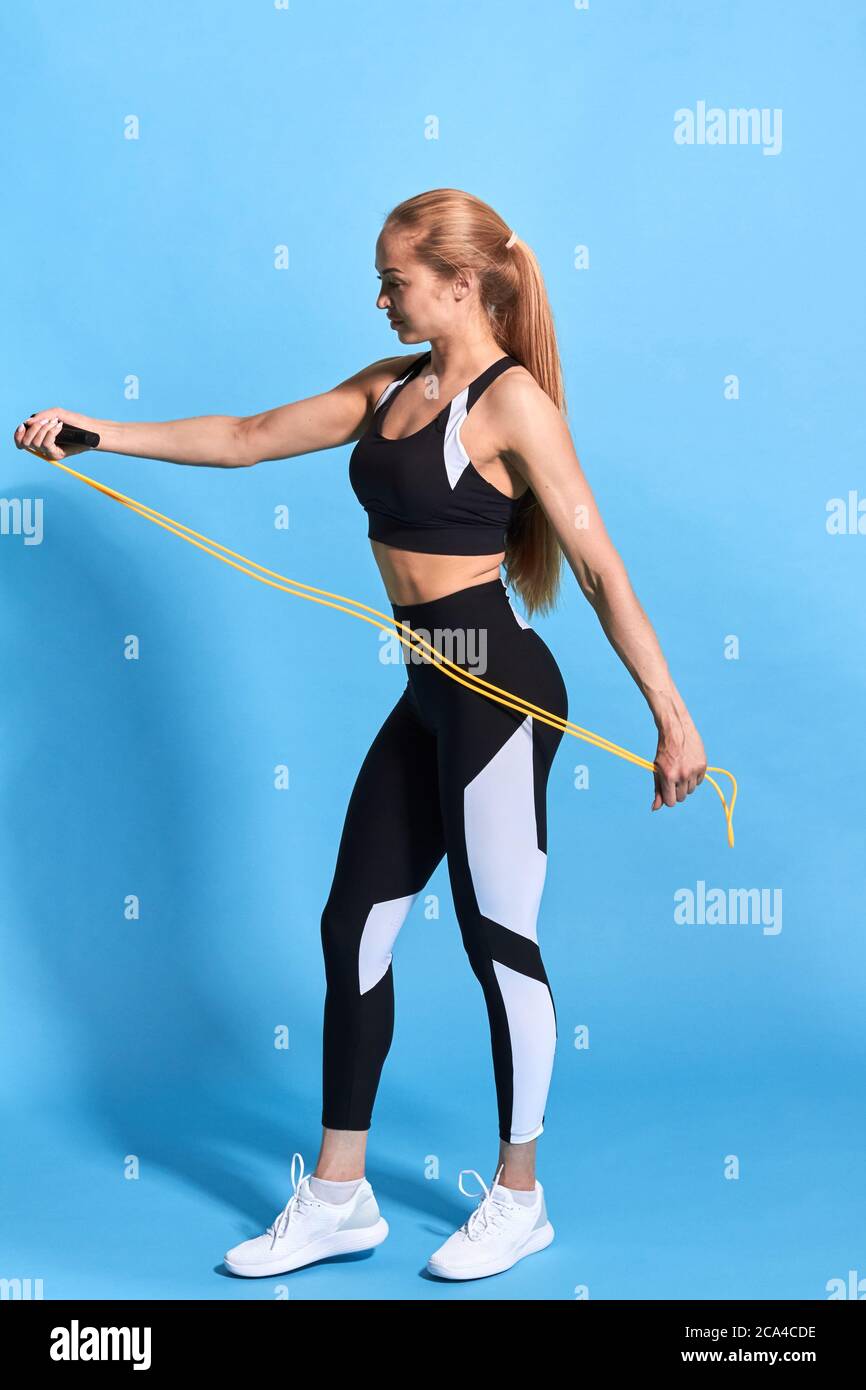 young personal trainer preparing, stretching a rope for workout. full ...