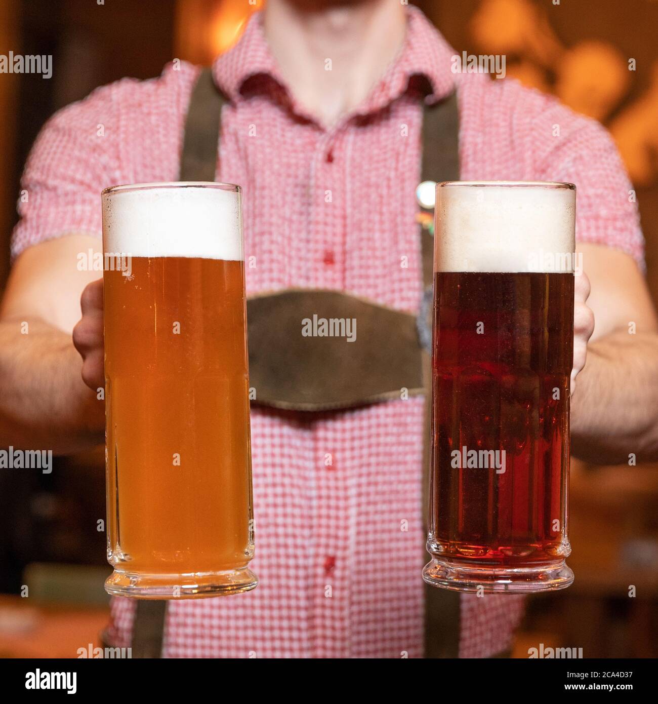 Man holding white and black, dark beer glasses side by side Stock Photo ...