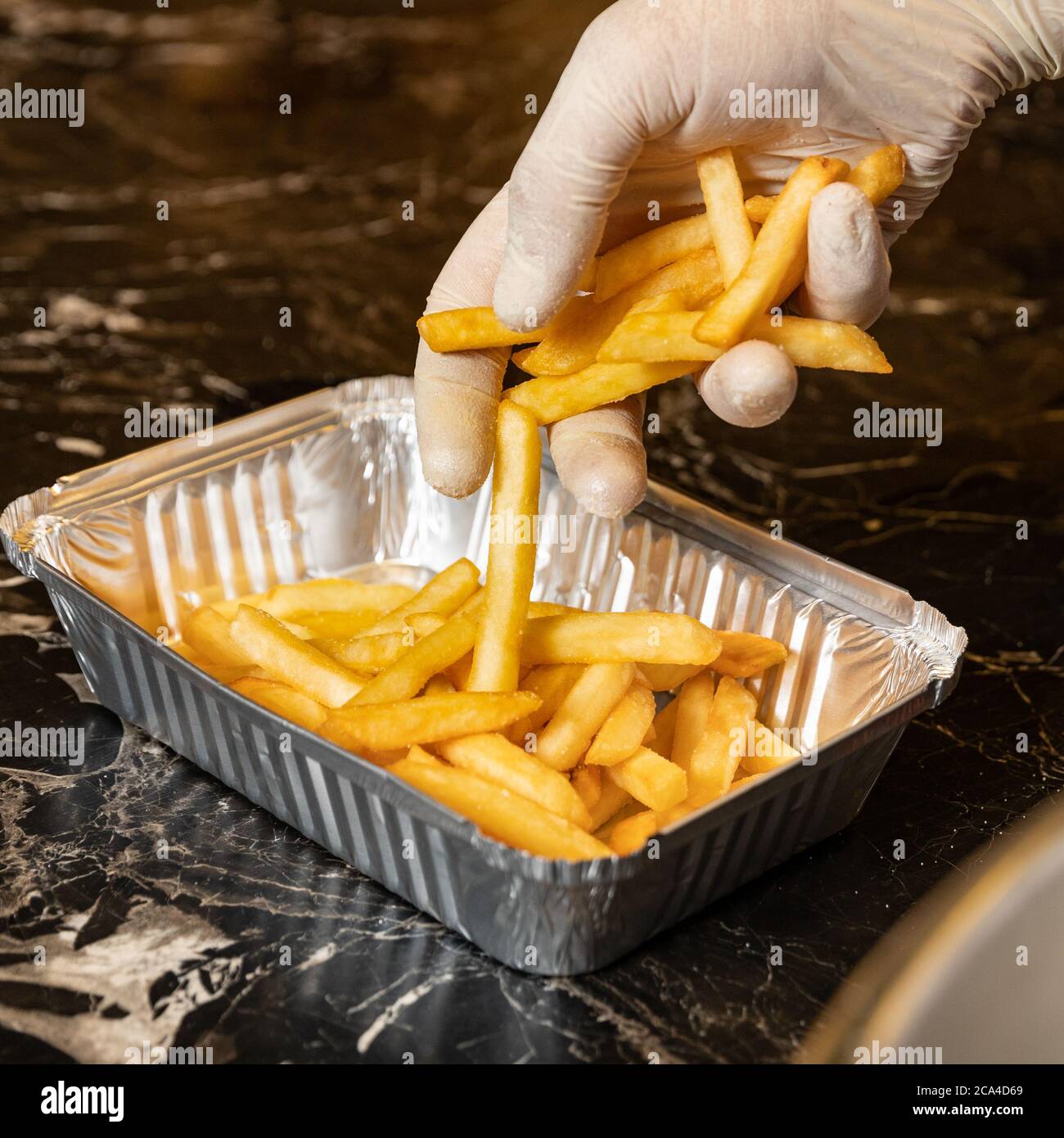 Chef putting french fries to the box Stock Photo - Alamy