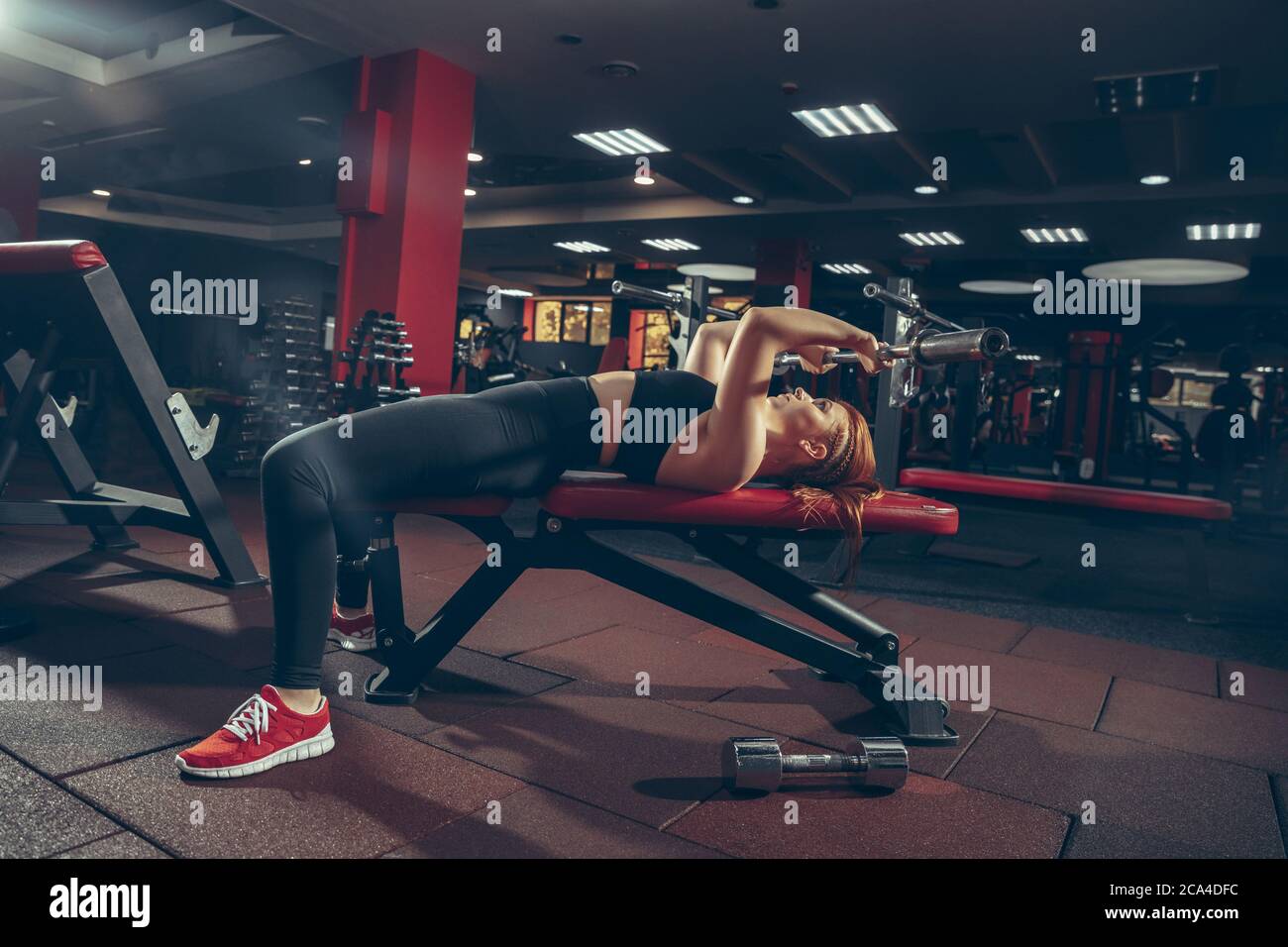 Power. Young muscular caucasian woman practicing in gym with equipment ...