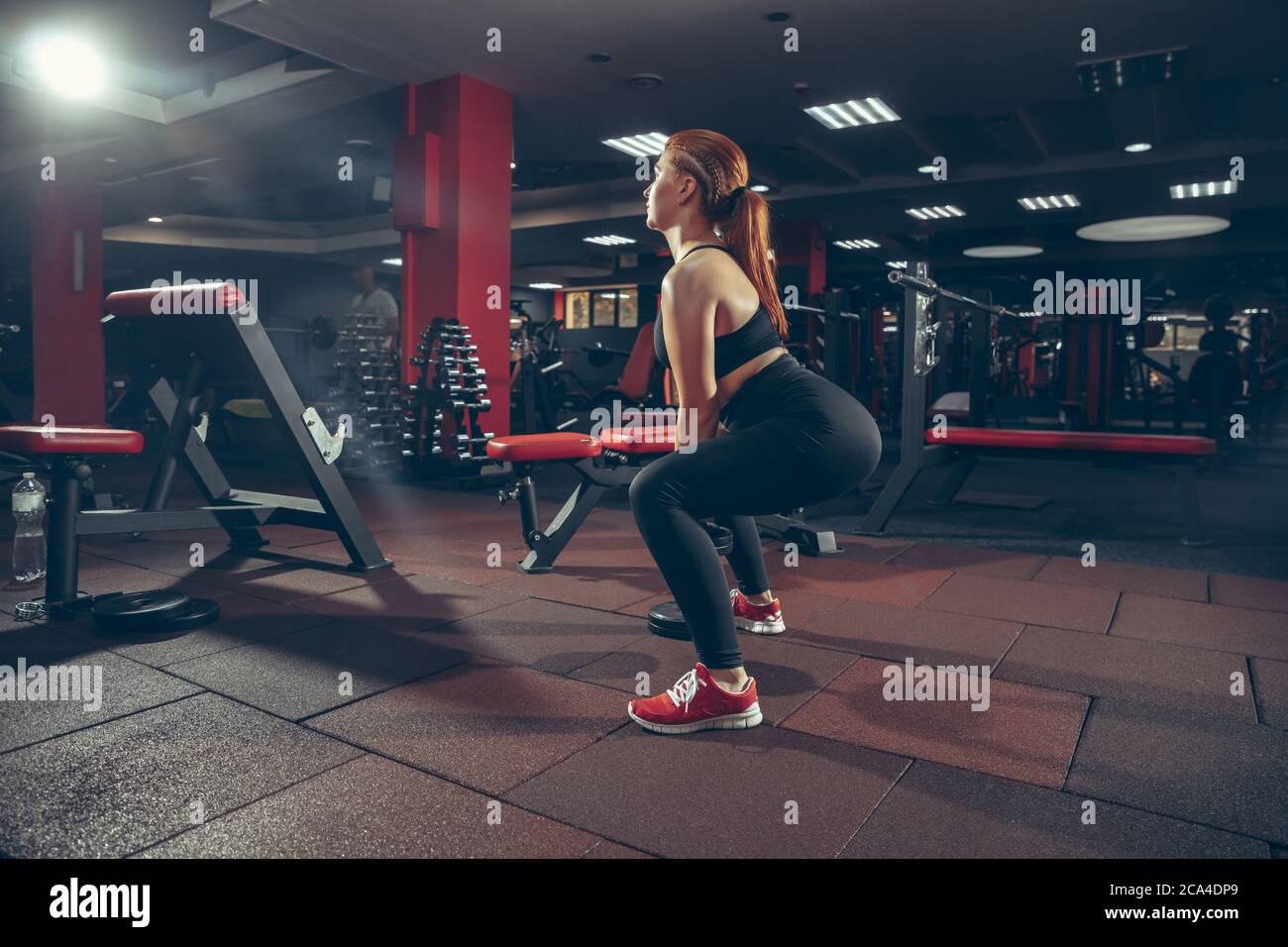 Sit up. Young muscular caucasian woman practicing in gym with equipment ...