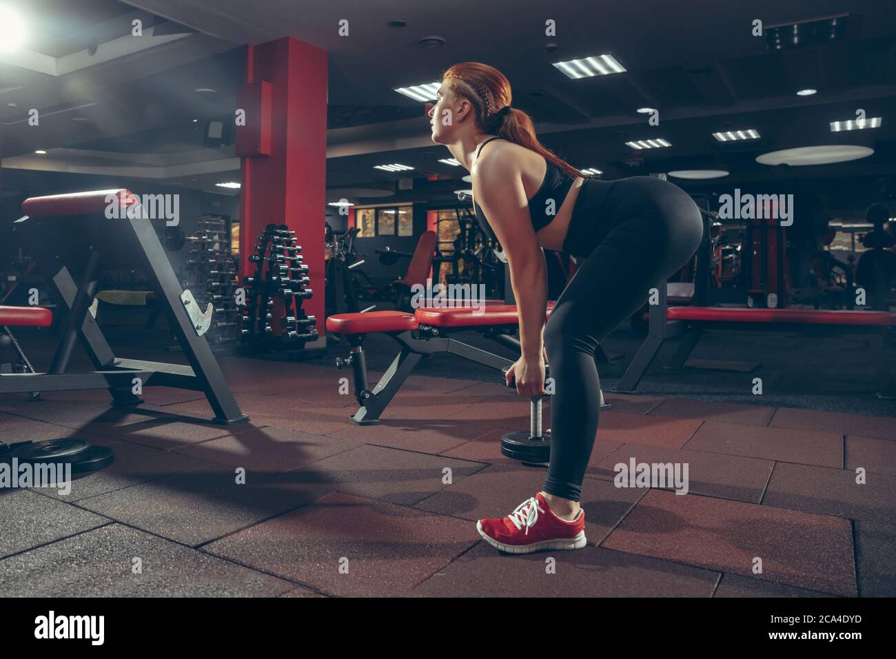 Sit up. Young muscular caucasian woman practicing in gym with equipment ...